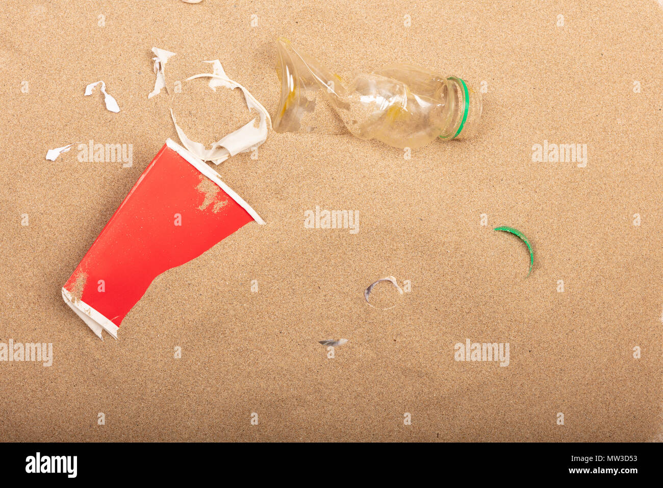 Waste plastic bottles and other types of wastes are lying on the sand ...