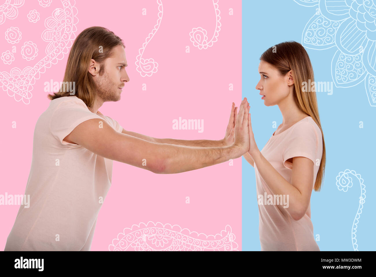 Worried woman looking scared while her boyfriend pushing her hands ...