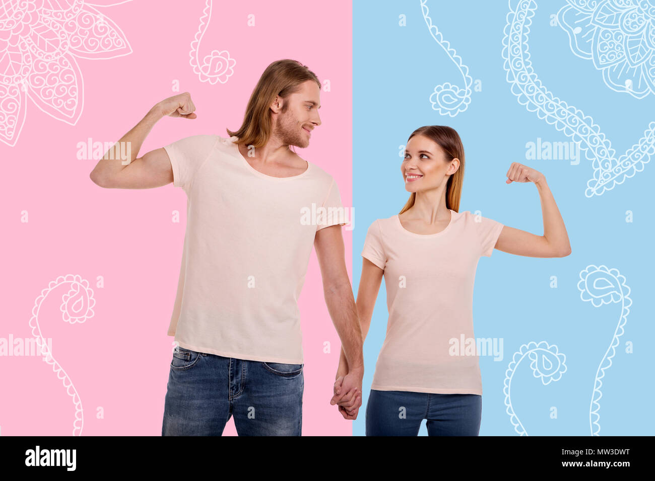 Cheerful couple holding hands and showing their strength Stock Photo ...