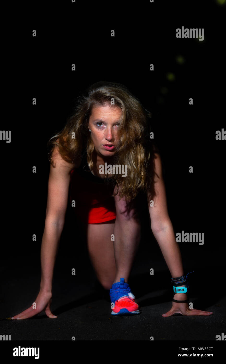 Athlete girl in starting position for running Stock Photo - Alamy