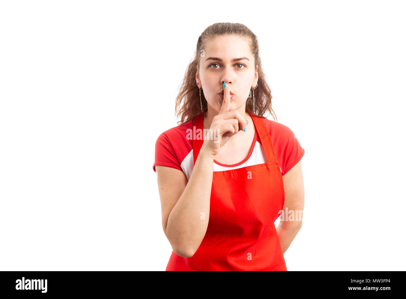 Young female supermarket or hypermarket employee making shush gesture ...