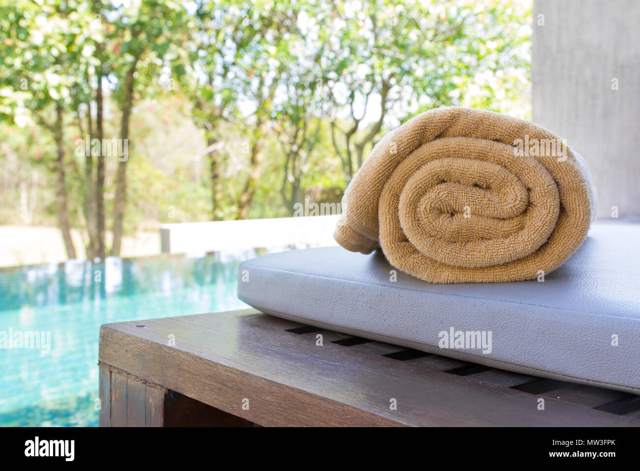 Rolled orange towel placed on the bed beside the pool Stock Photo - Alamy