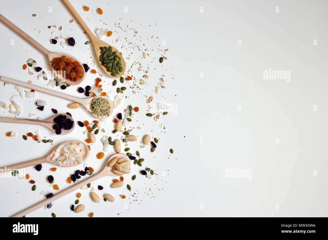 Concept of wooden spoons on the left side, full of seeds and cereals on ...