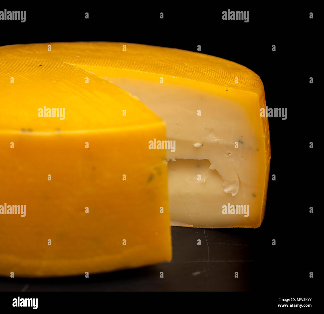 full wheel of semi-hard cheese from Azores, Portugal, on black slate ...