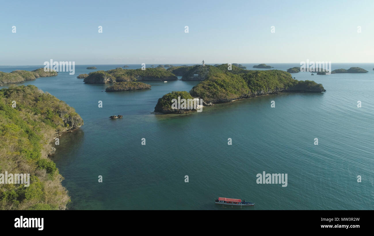 Small islands in Hundred Islands National Park with statue of Jesus ...