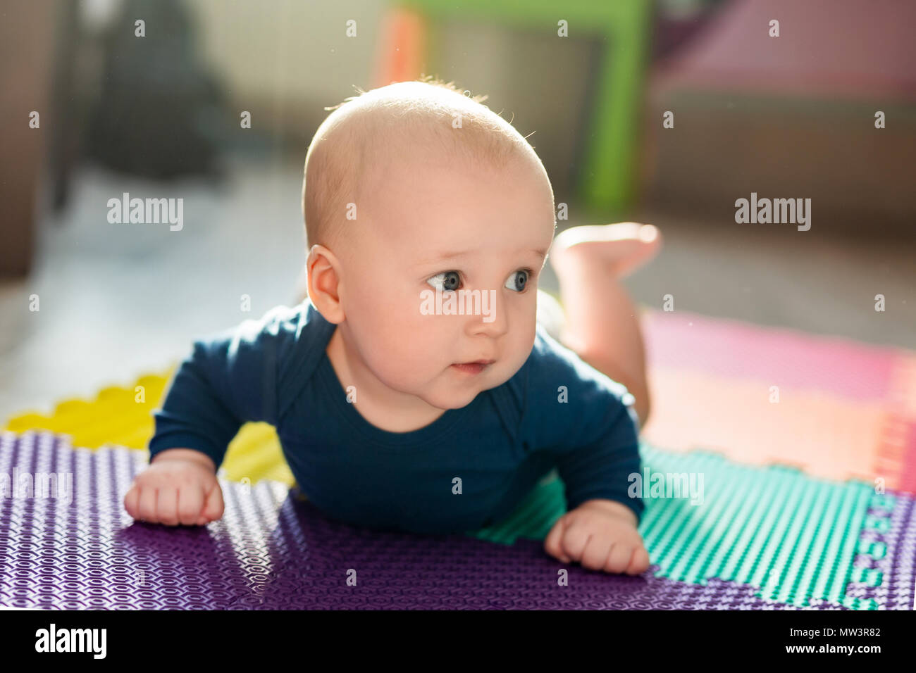 Infant baby boy playing on colorful soft mat. Little child making first ...