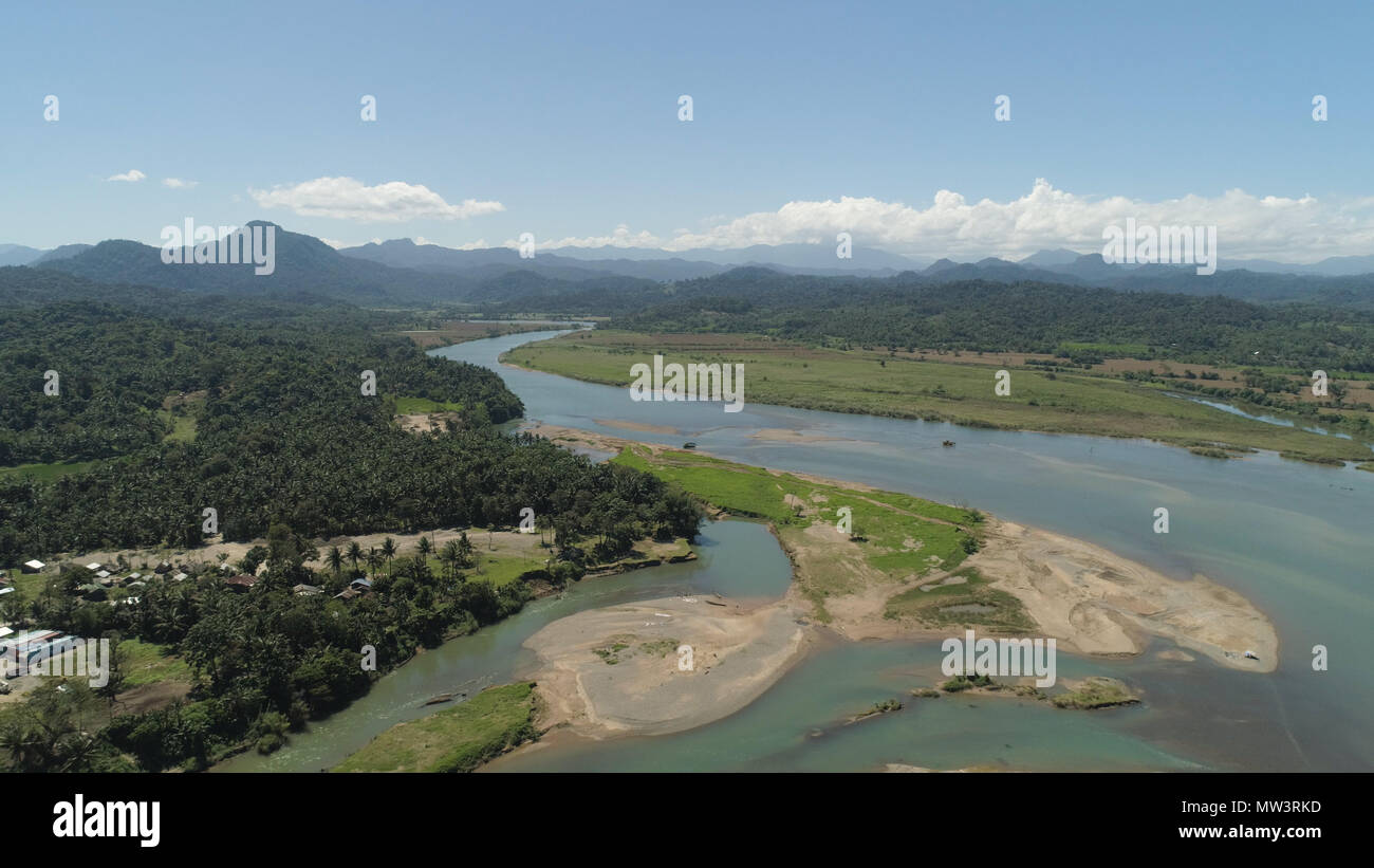River in mountain valley flowing through farmlands. Aerial view of ...