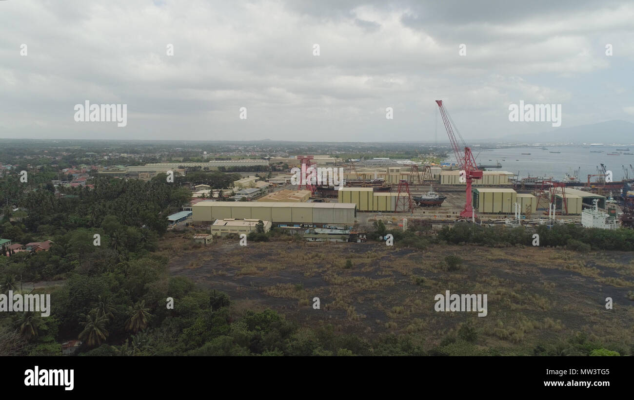 Aerial view of shipyard with ships in docks, cranes and warehouses ...