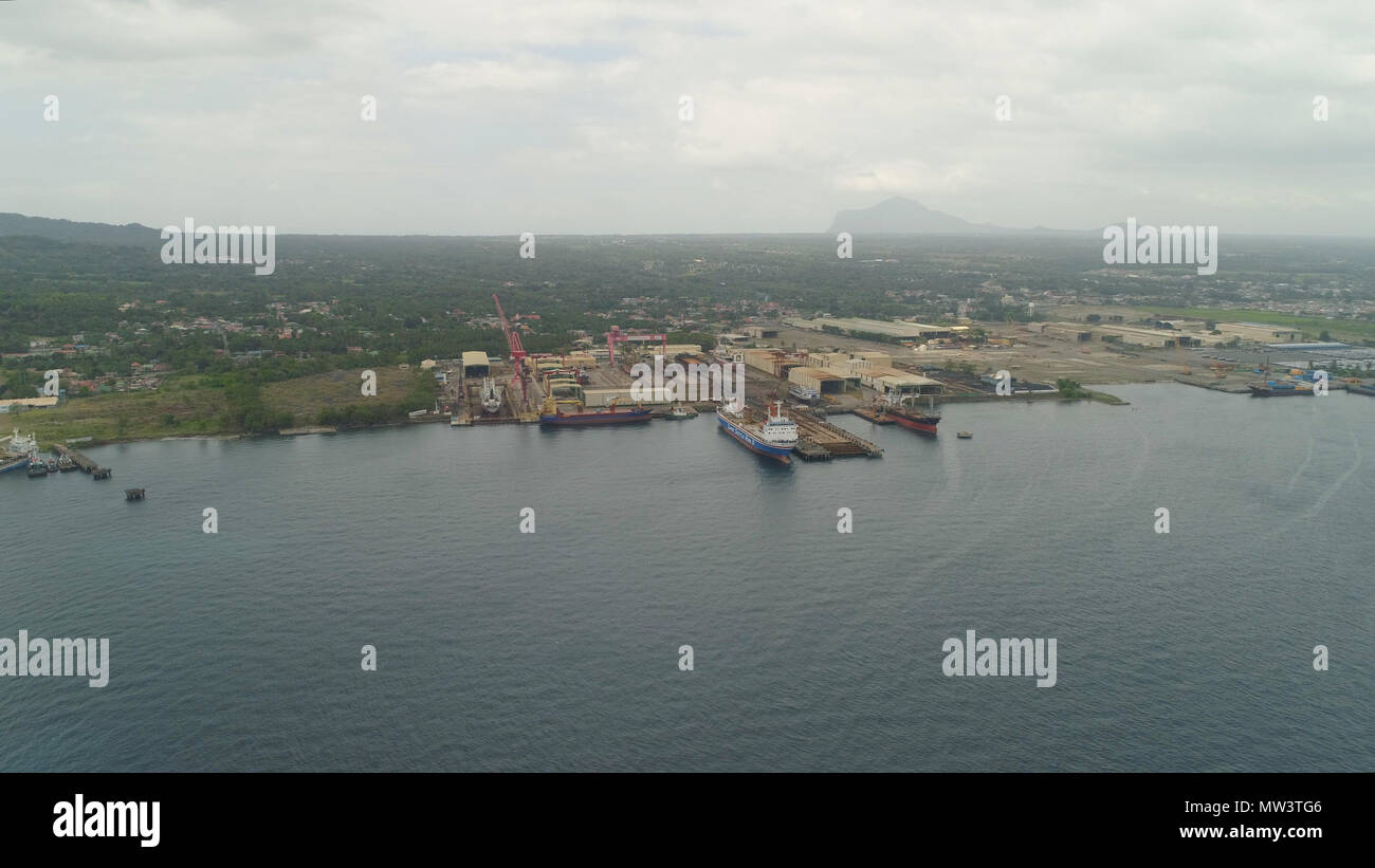Aerial view of shipyard with ships in docks, cranes and warehouses ...