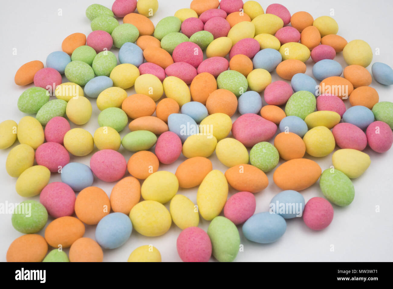 Small colorful chocolate candies on a white background Stock Photo - Alamy