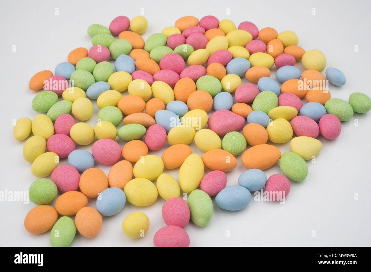 Small colorful chocolate candies on a white background Stock Photo - Alamy