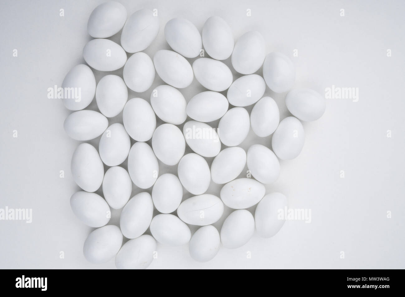 Small white candy on a white background Stock Photo - Alamy