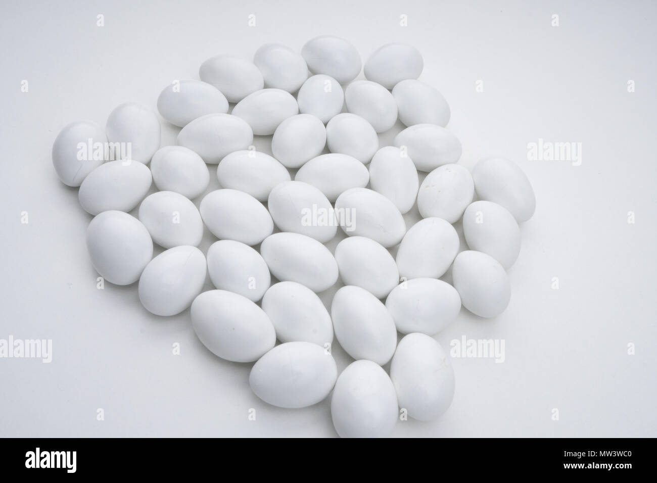 Small white candy on a white background Stock Photo - Alamy
