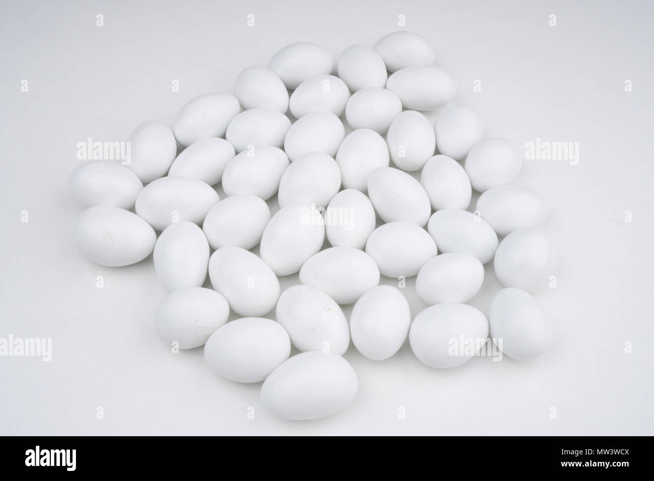 Small white candy on a white background Stock Photo - Alamy