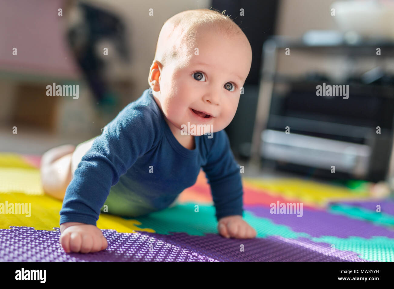 Infant baby boy playing on colorful soft mat. Little child making first ...
