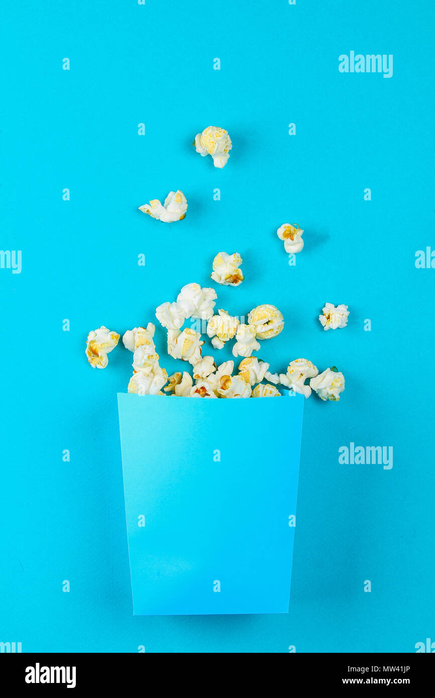 Box of popcorn spilled on blue background Stock Photo - Alamy