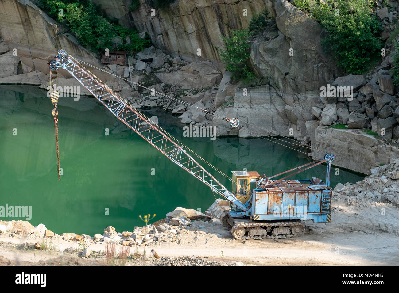 Mining in the granite quarry. Working mining machine - old crane ...