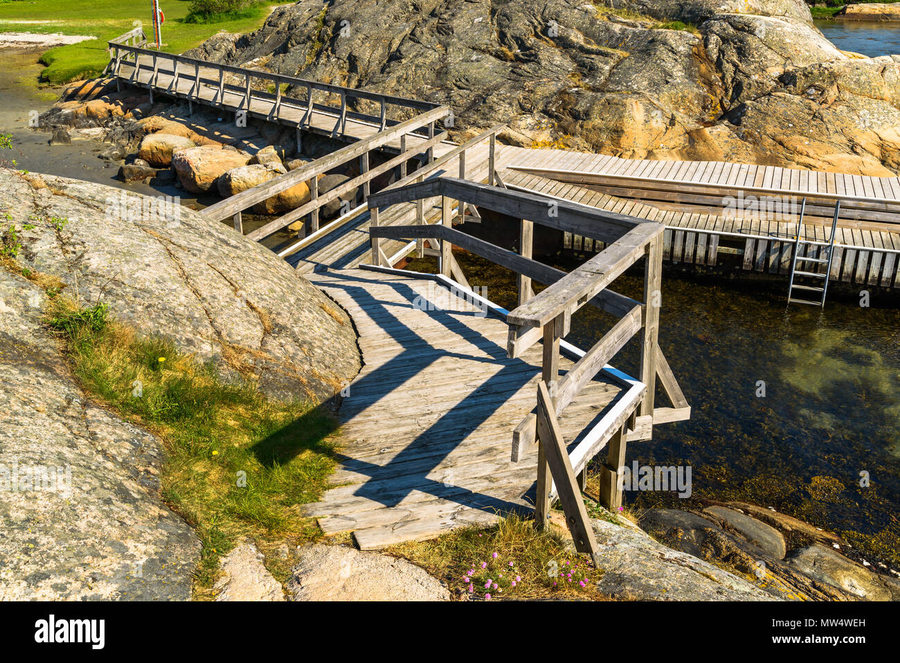 Wooden bathing piers and ramps in coastal landscape on a sunny day. The ...
