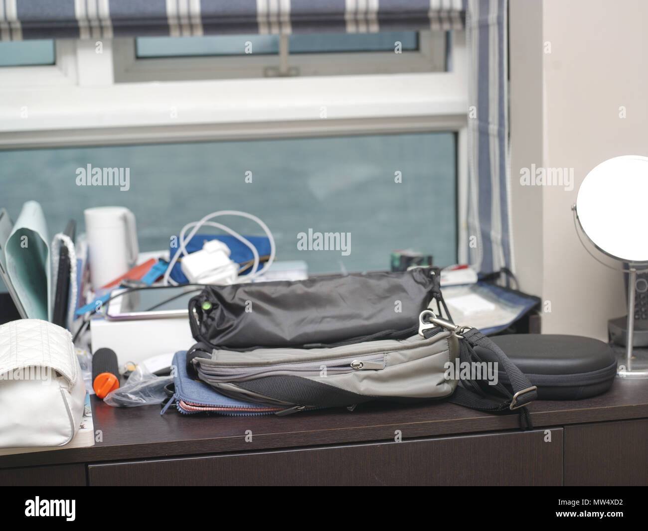 Personal belongings on a table against the window Stock Photo - Alamy