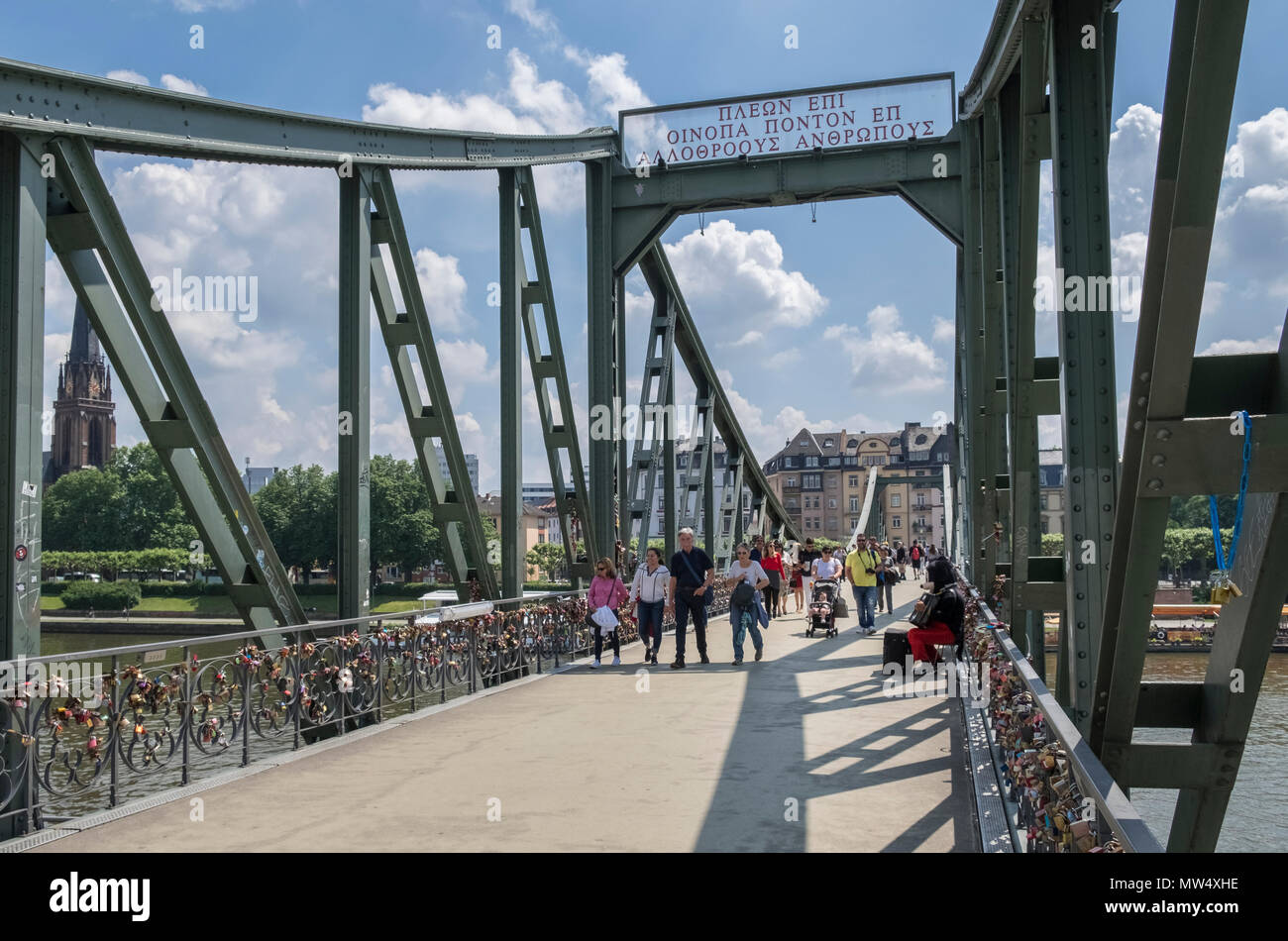 Pedestrians walking over the Eiserner Steg iron footbridge across the ...