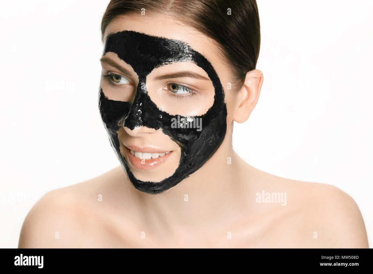 Young beautiful woman applying a mask for the face of the therapeutic ...