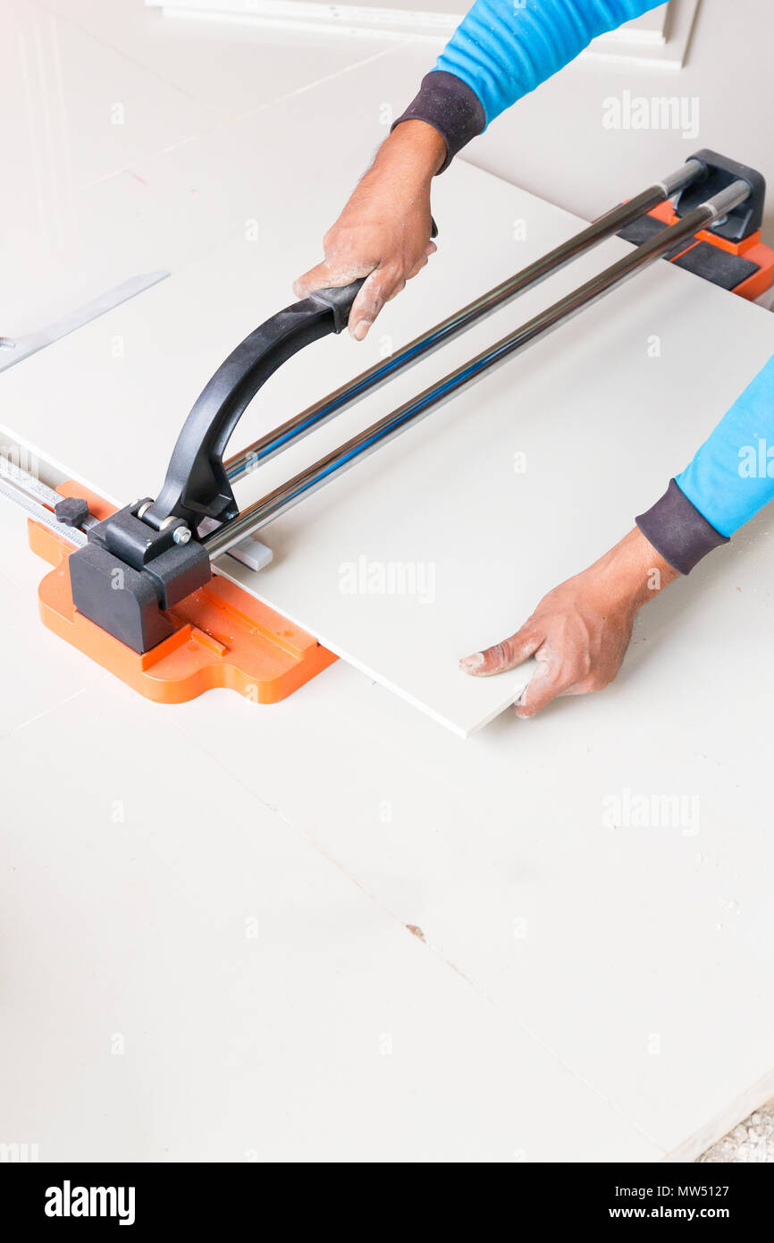 Industrial tiler builder worker working with floor tile cutting ...
