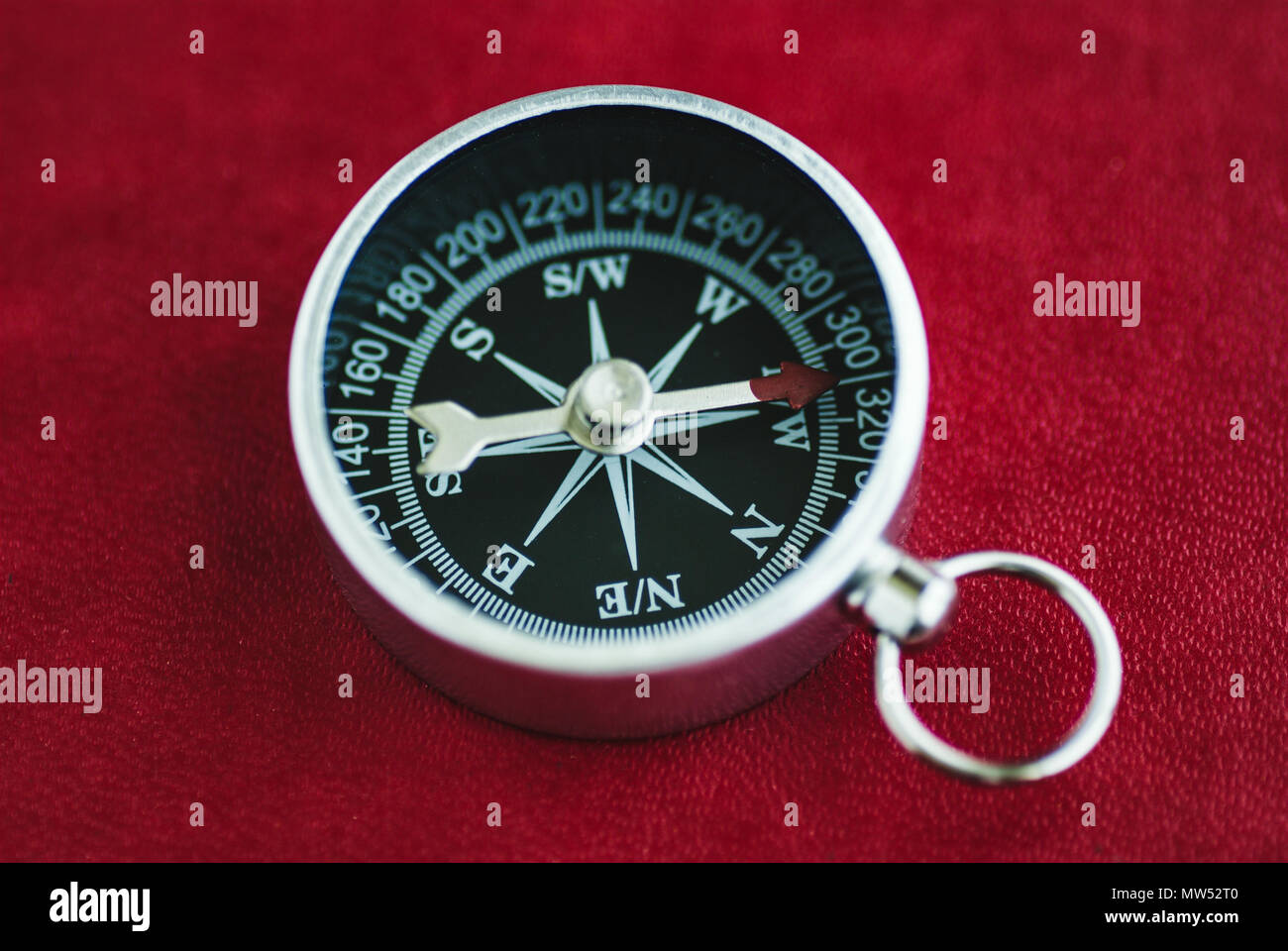 Black traditional compass with arrow on red background Stock Photo - Alamy