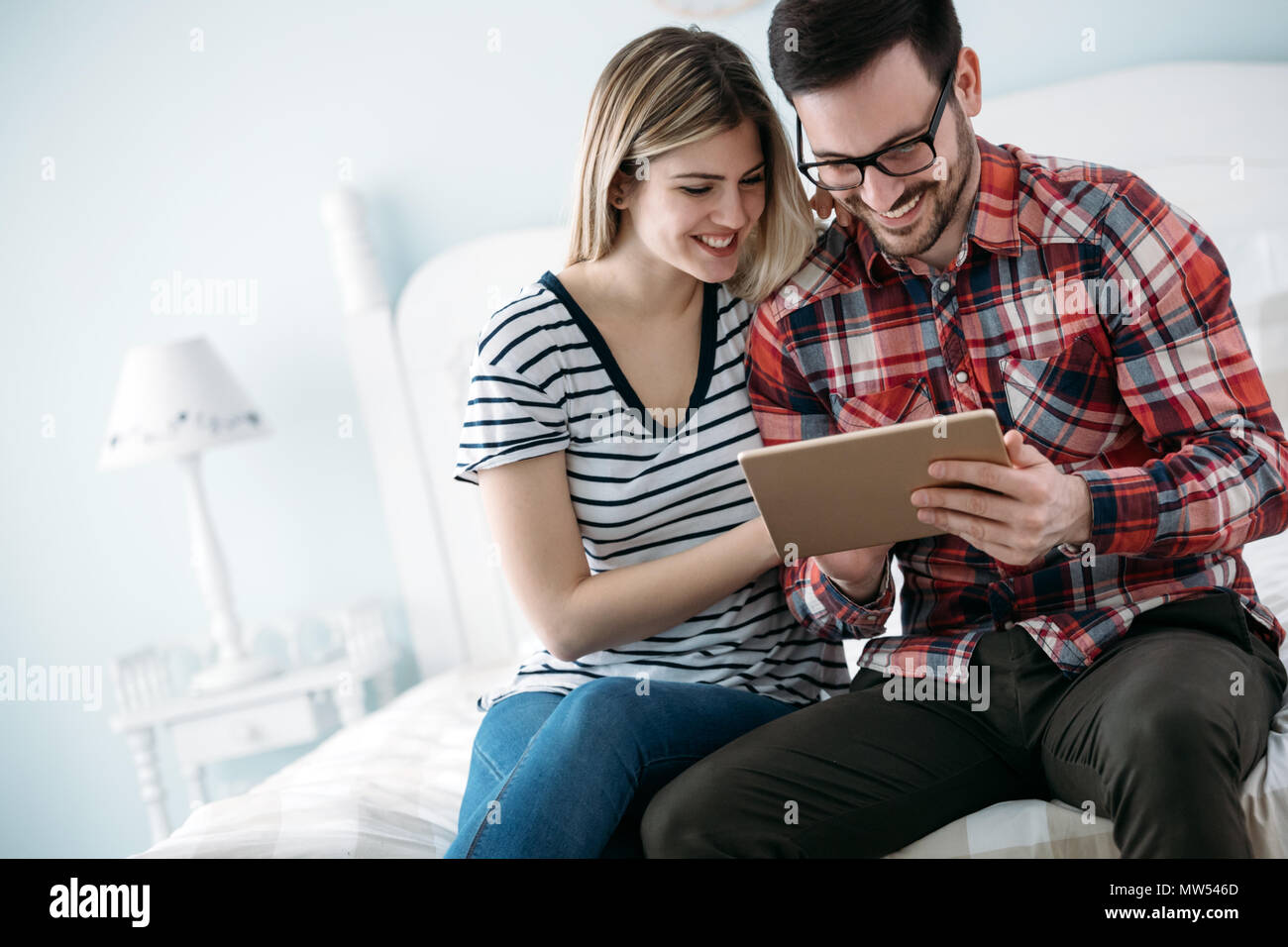 Happy young couple using tablet hi-res stock photography and images - Alamy