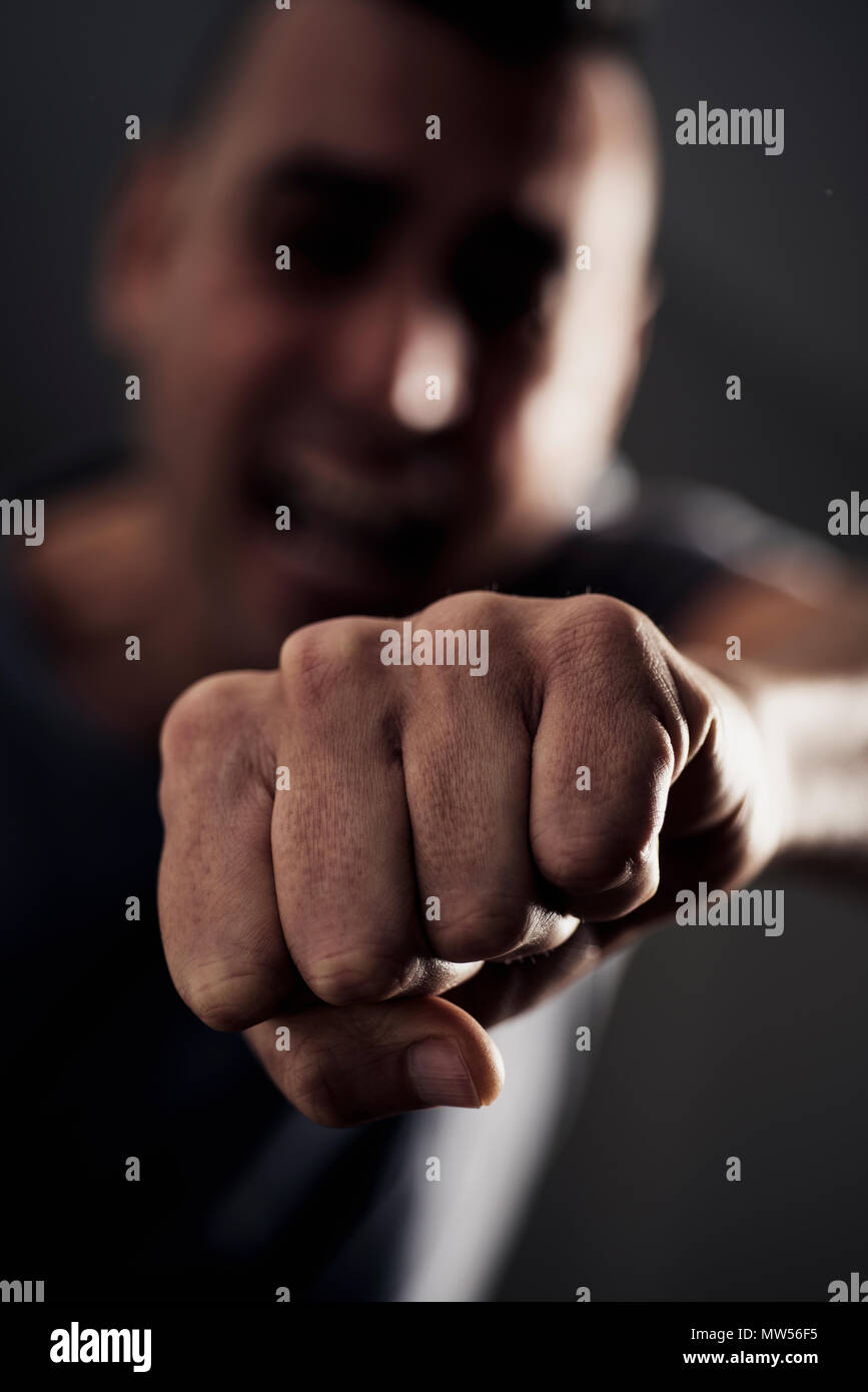 closeup of a young caucasian man throwing a punch to the observer, with ...