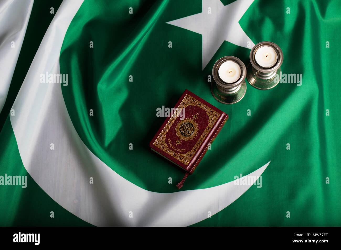 Quran and candles on a flag of Pakistan. Translation into English - the ...