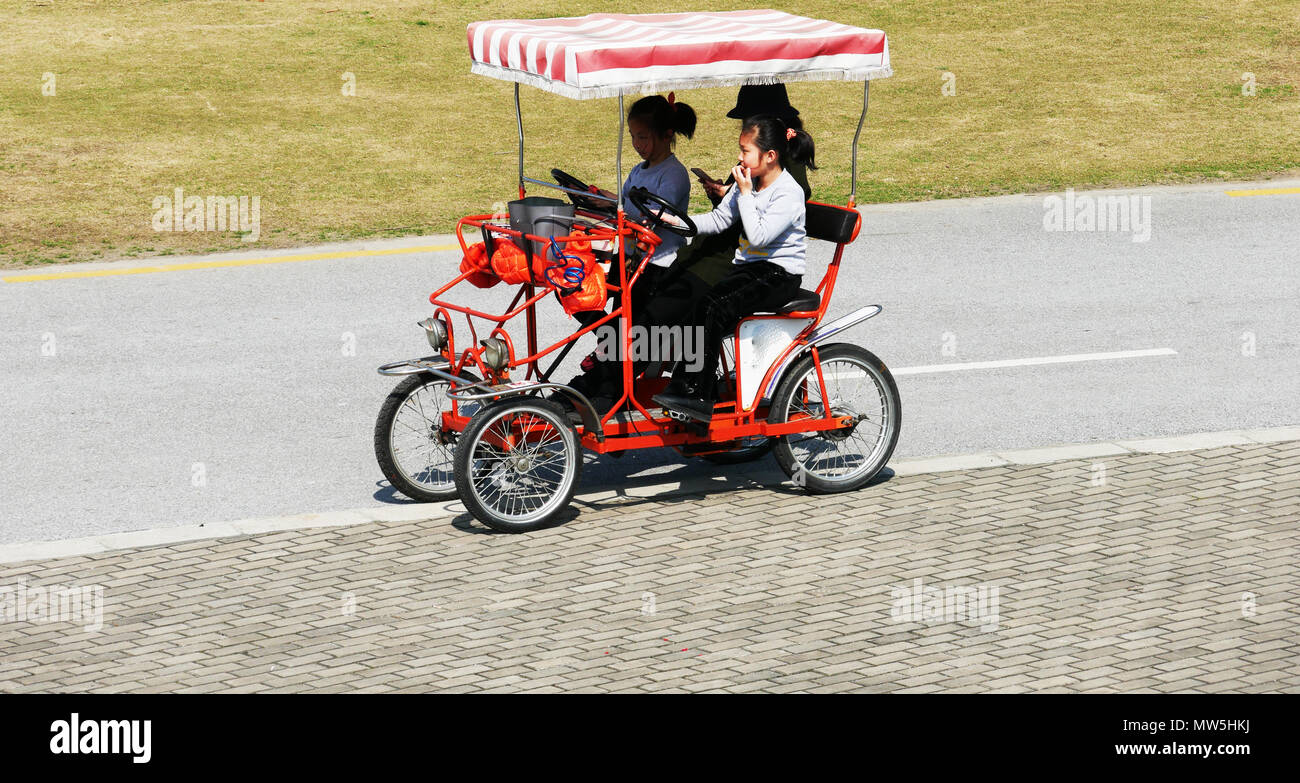 Chinese children riding a pedal car in the park Stock Photo - Alamy