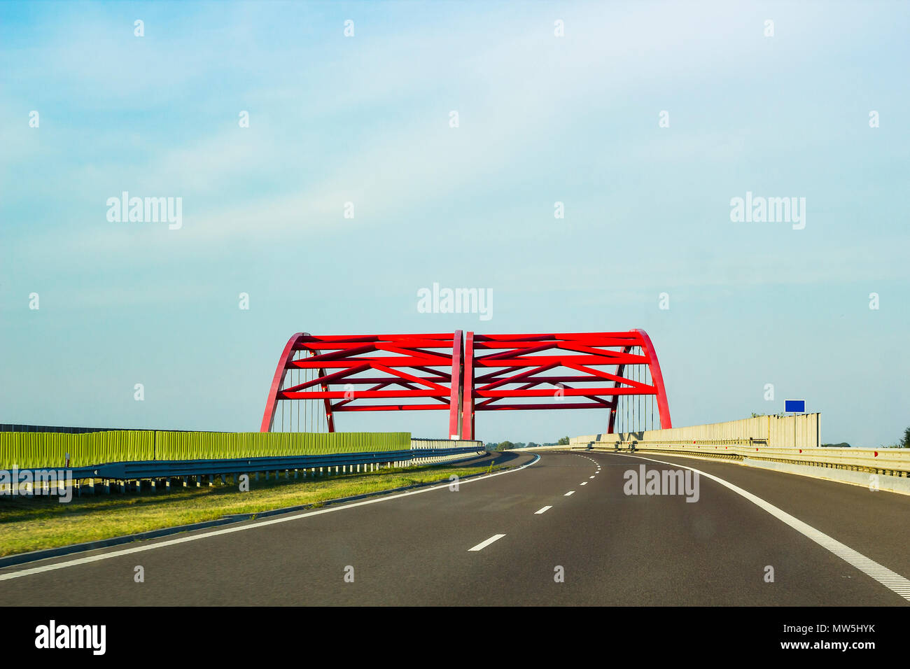 Summer landscape with empty asphalt high-speed road and red metal ...