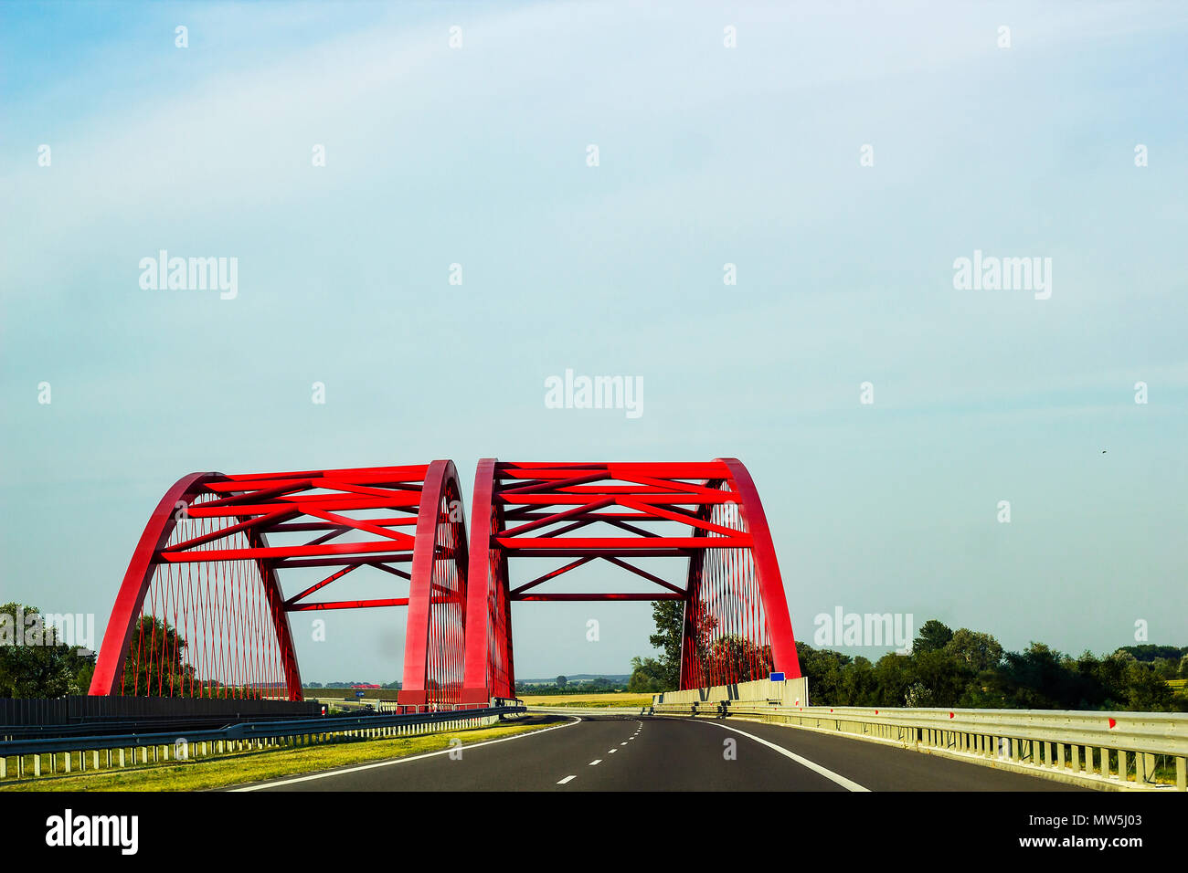 Summer landscape with empty asphalt high-speed road and red metal ...