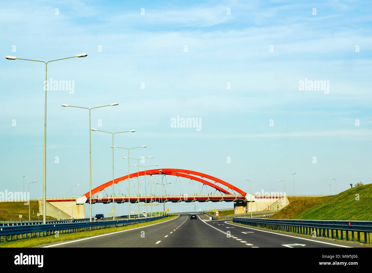 Cars driving on asphalt road. Summer landscape with road, red arch of ...