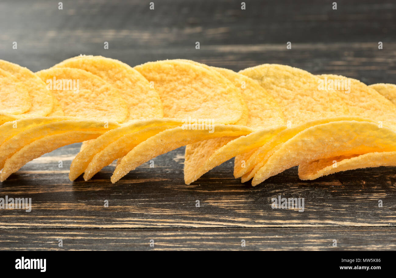 Scattered potato chips on a dark table closeup Stock Photo - Alamy