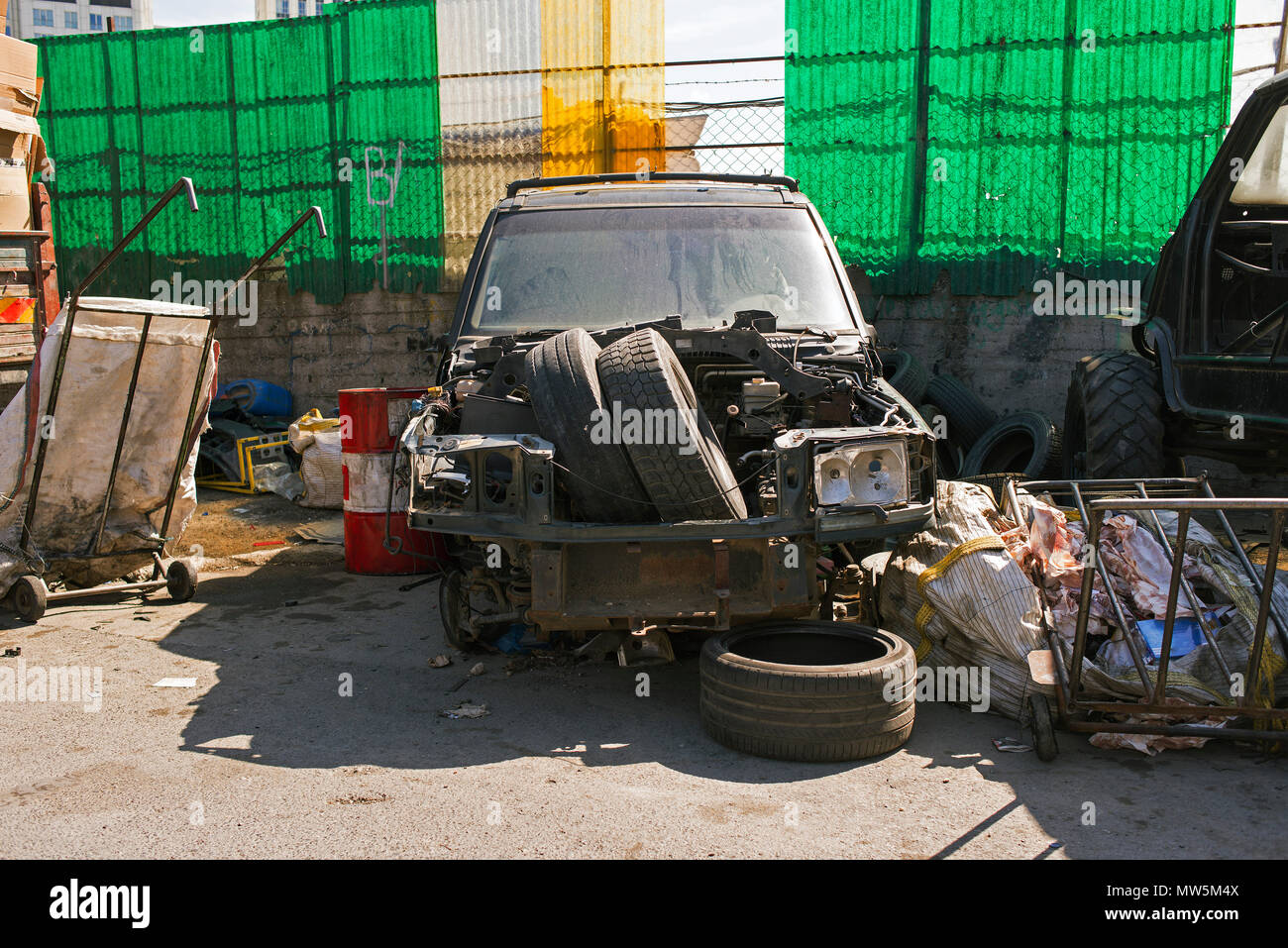 Front view of a wrecked SUV in a parking lot with garbage in the street ...
