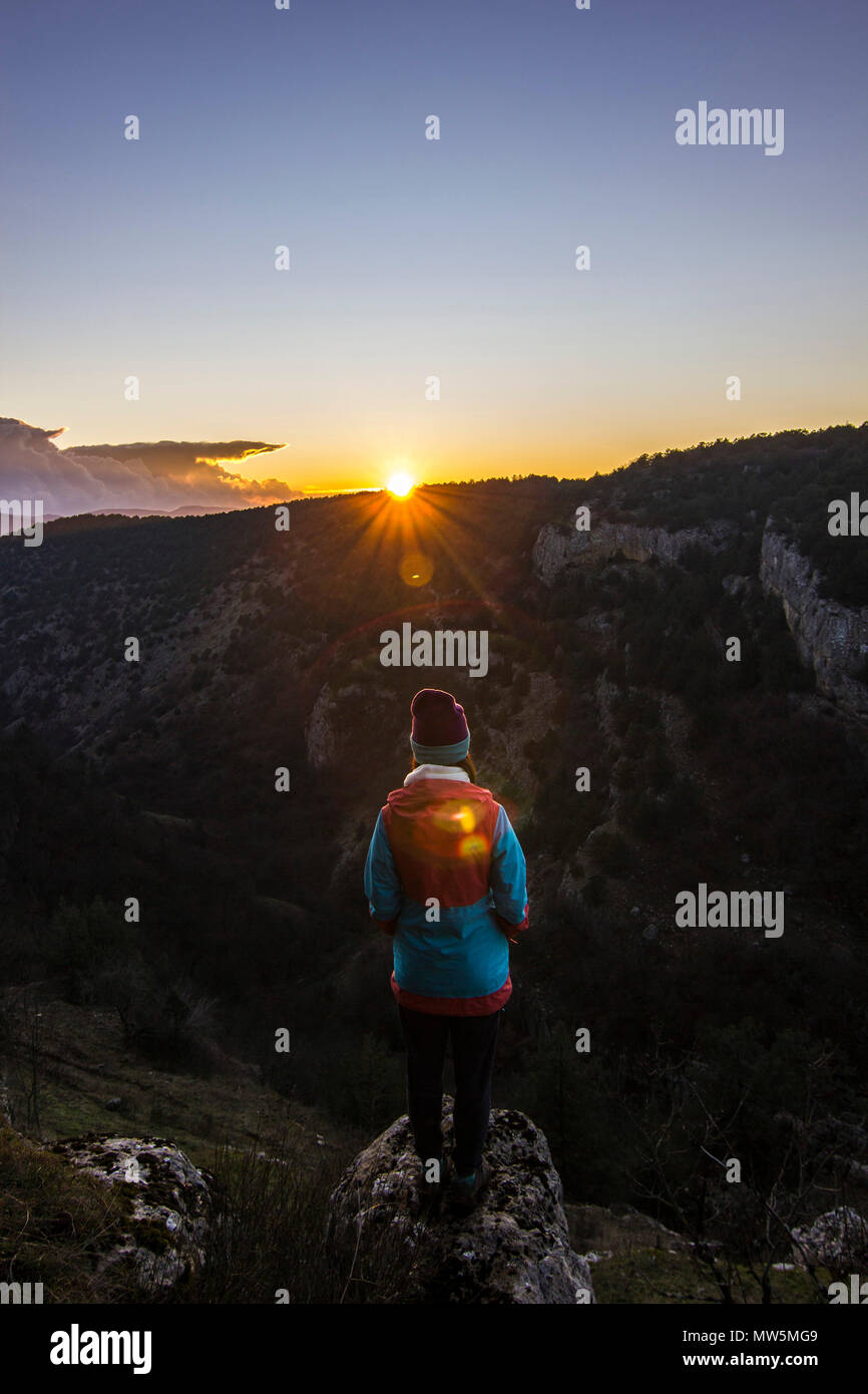 girl standing on a cliff in mountains at sunset Stock Photo - Alamy