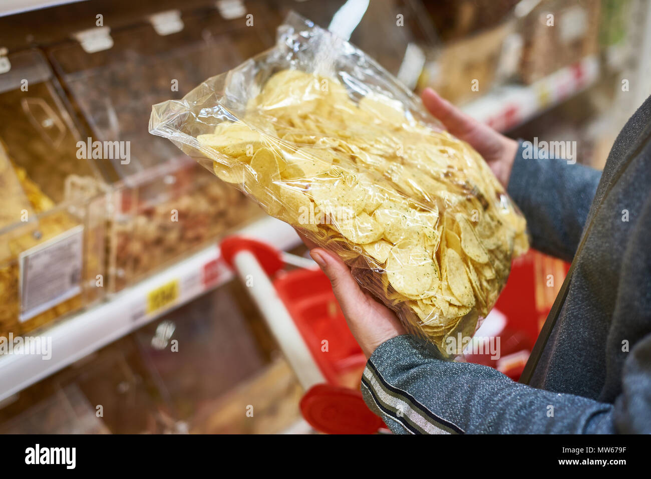 Packing of potato chips in the buyers hand in the grocery store Stock ...