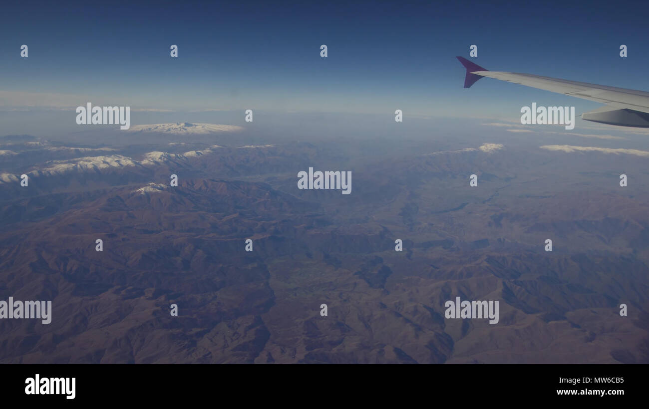 Mountain range from the airplane window. Airplane wing. Aerial view on ...