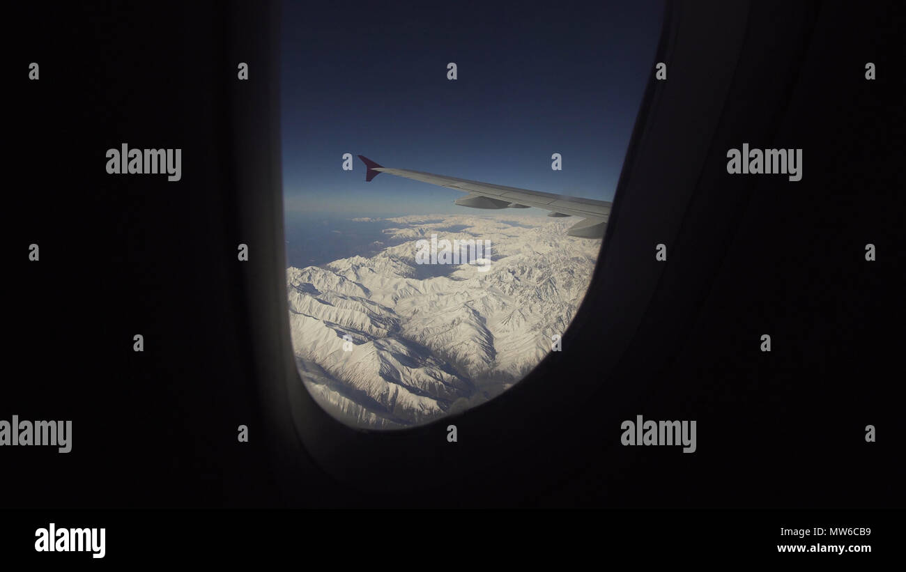 Mountain range with snow from the airplane window. Airplane wing ...