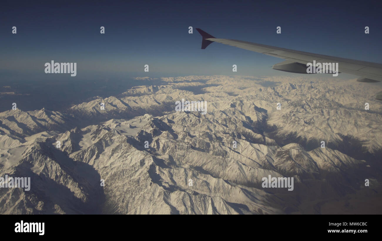 Mountain range with snow from the airplane window. Airplane wing ...