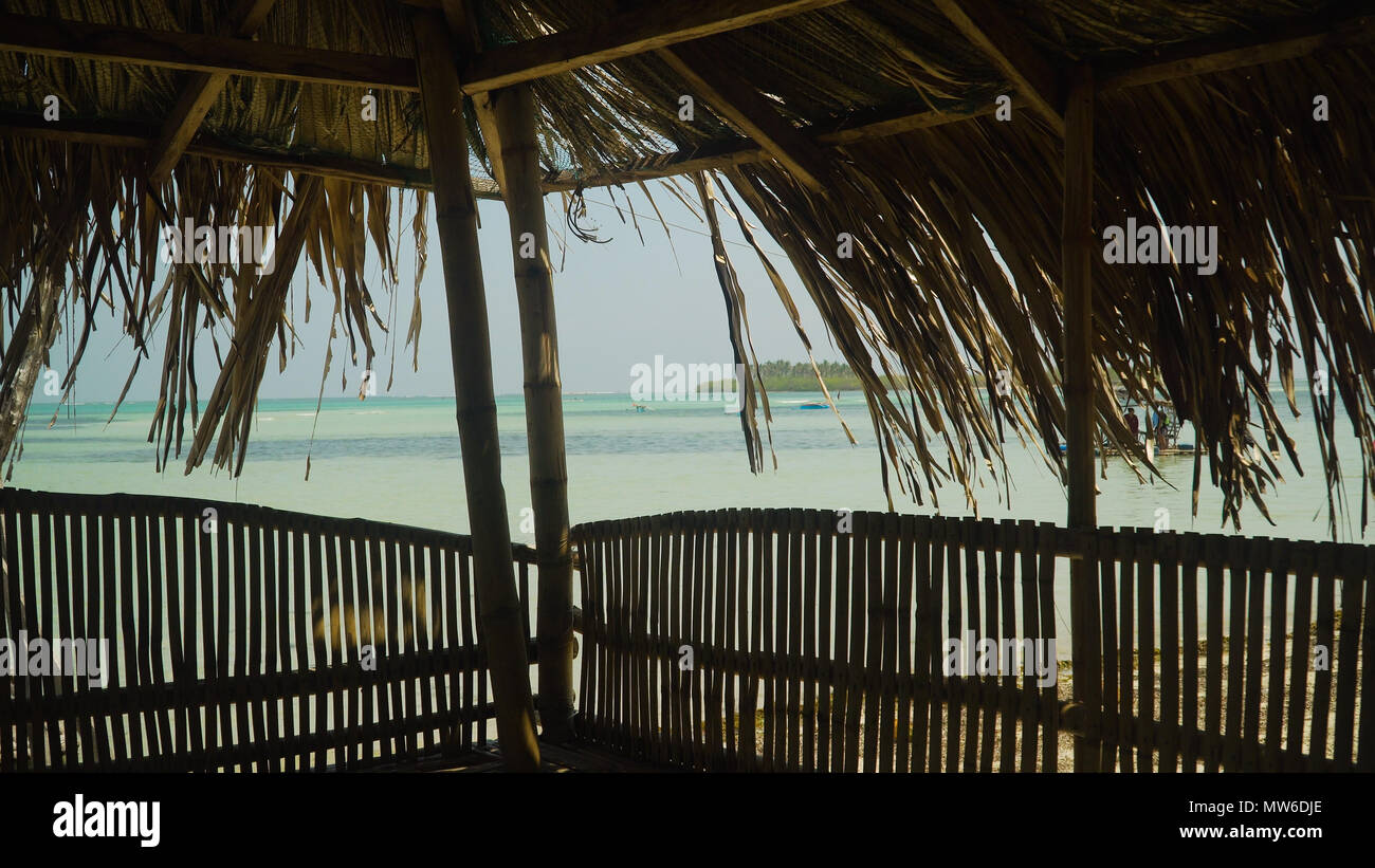 Tropical island with white sandy beach, palm trees in blue lagoon ...