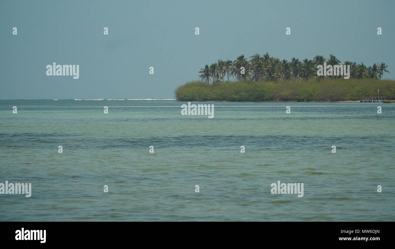 Tropical island with white sandy beach, palm trees in blue lagoon ...