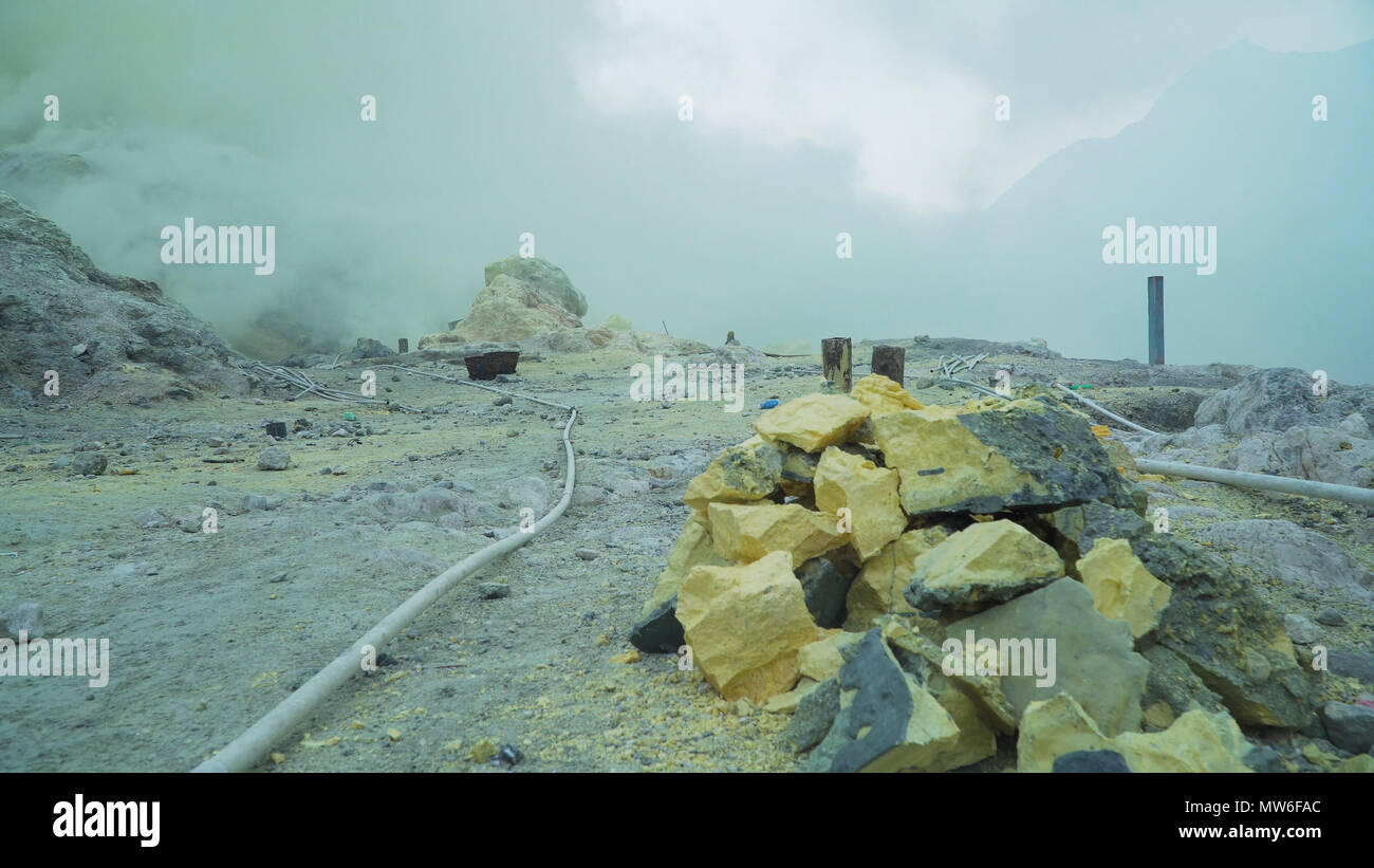 Extraction of sulfur in the crater of a volcano. Sulfur gas, smoke ...