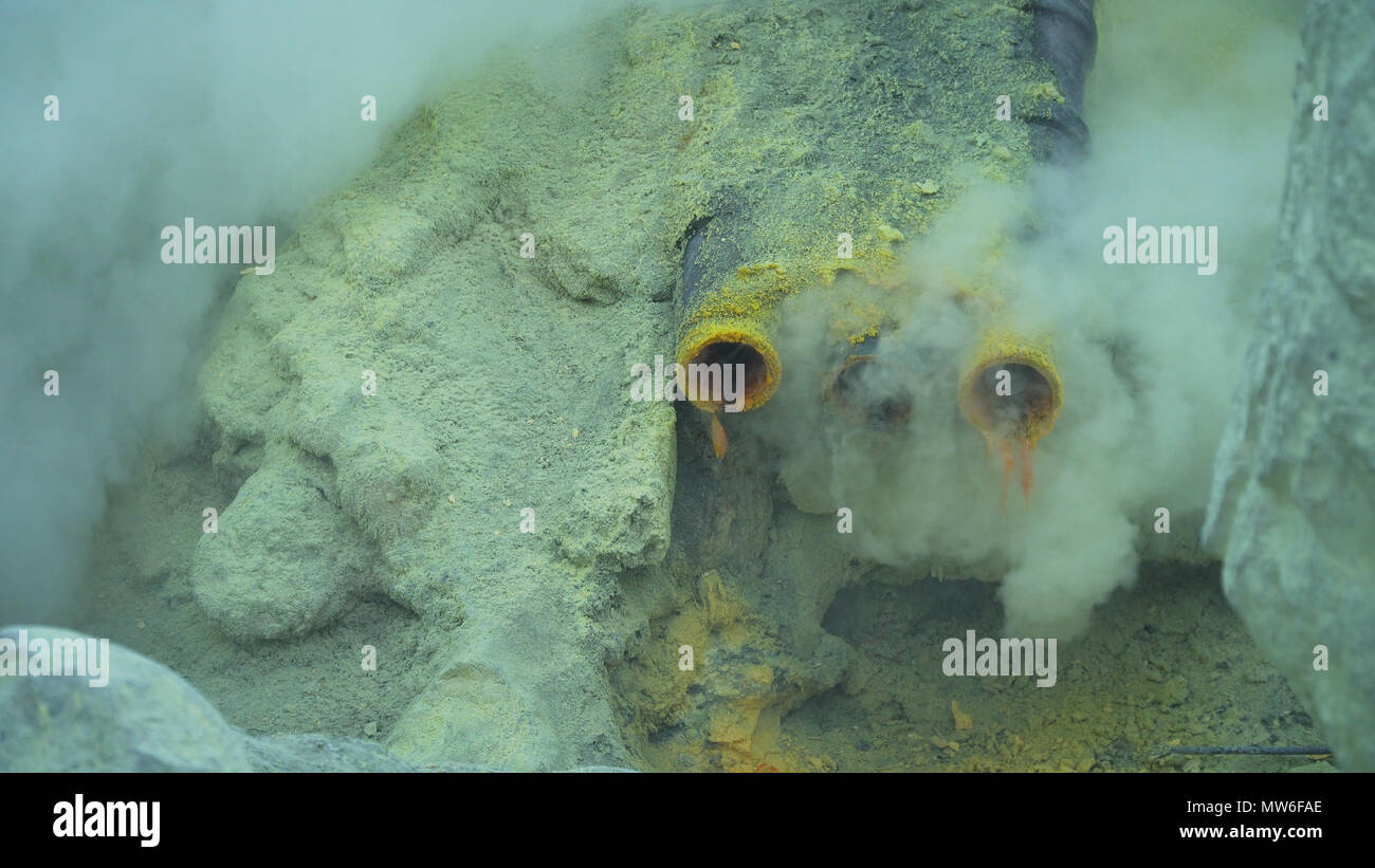 Extraction of sulfur in the crater of a volcano. Sulfur gas, smoke ...