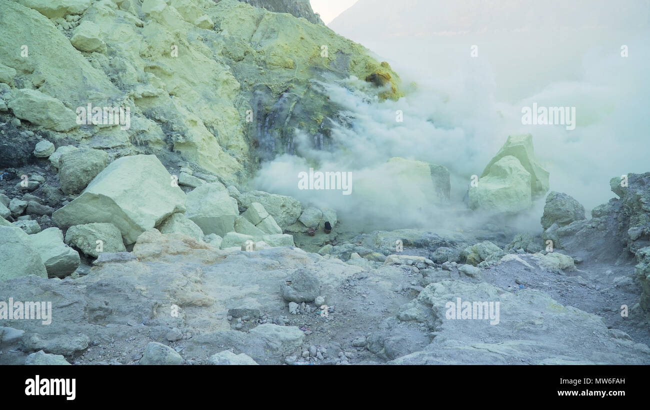 Extraction of sulfur in the crater of a volcano. Sulfur gas, smoke ...