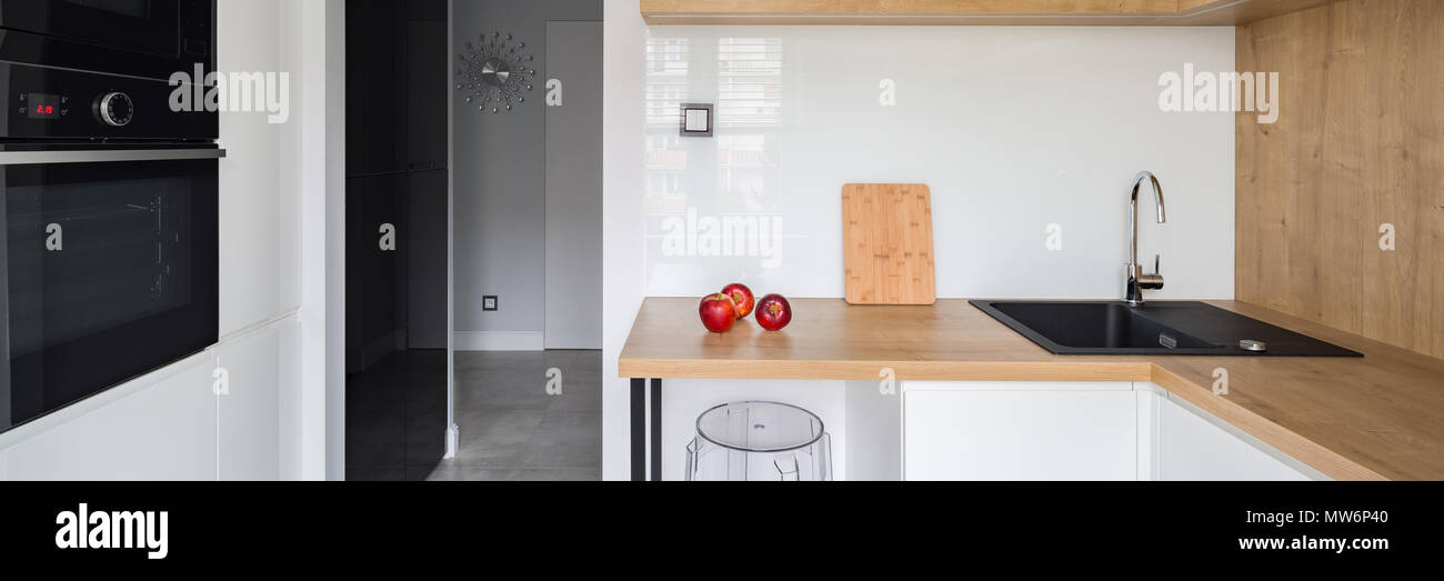 Modern, white kitchen with wooden worktop and transparent chair ...