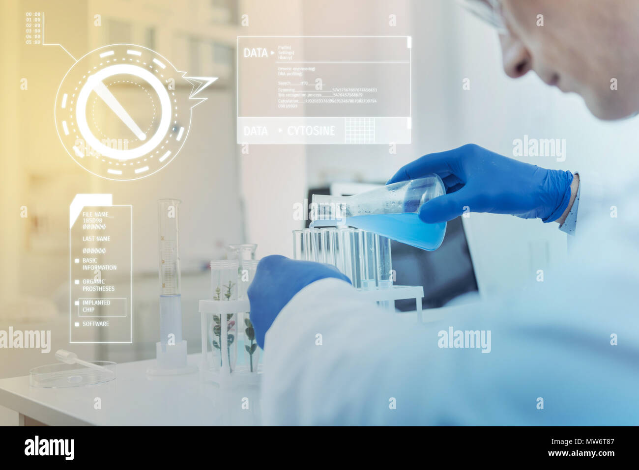 Careful scientist pouring blue liquid into test tubes while being in a ...