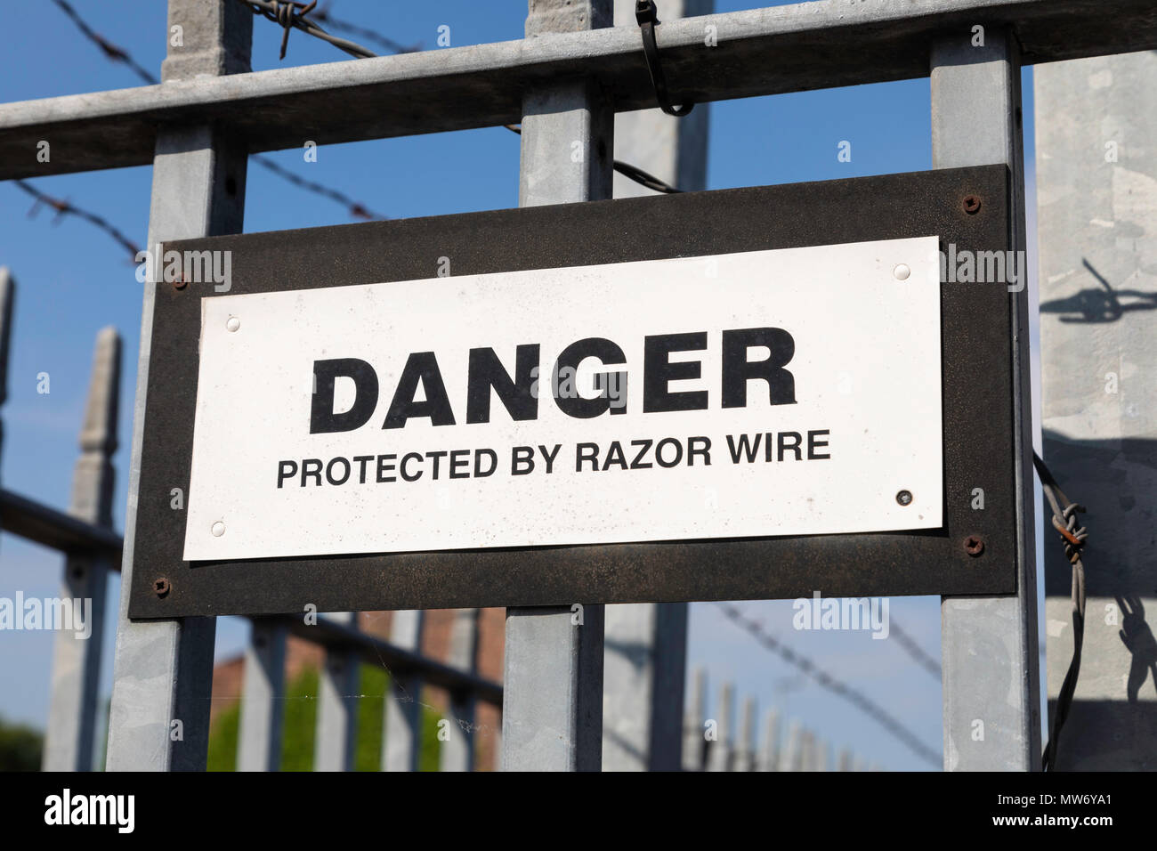 A warning sign stating Danger Protected by Razor Wire mounted on ...