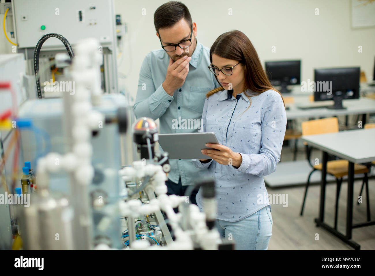 Young couple of students working at robotics lab Stock Photo - Alamy
